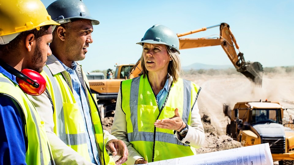 People in fluro vests standing and talking at a mining site