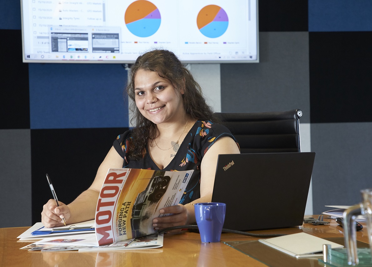 A woman reviewing a magazine and making notes